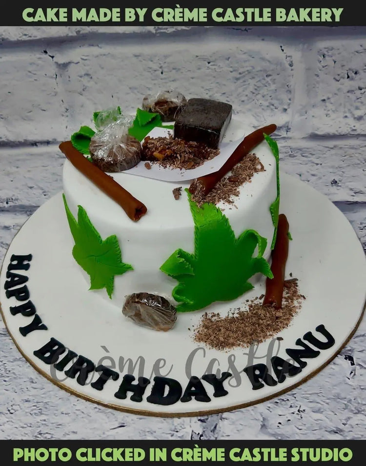 A marijuana themed cake with leaf in the front and joints and stuff ...