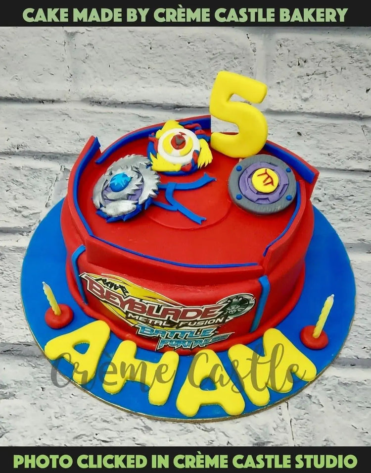 A beyblade theme cake with some amazing beyblades rolling over the top ...